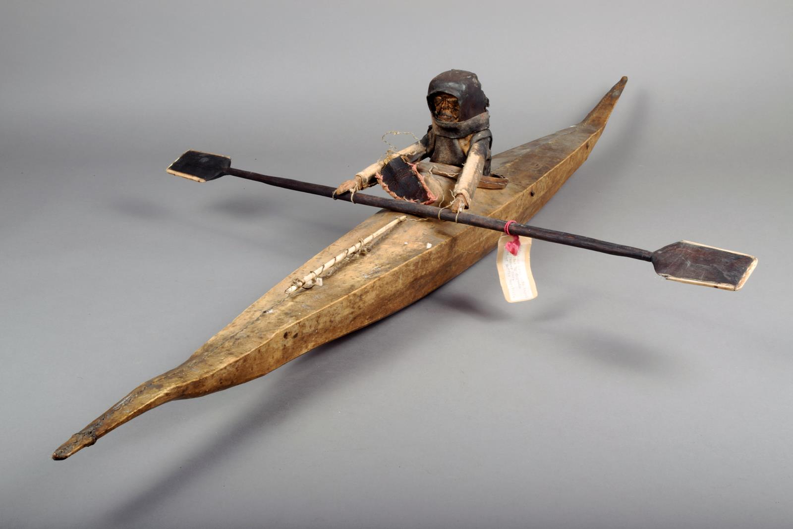An Inuit model kayak seal skin on a wooden frame with a carved wood ...