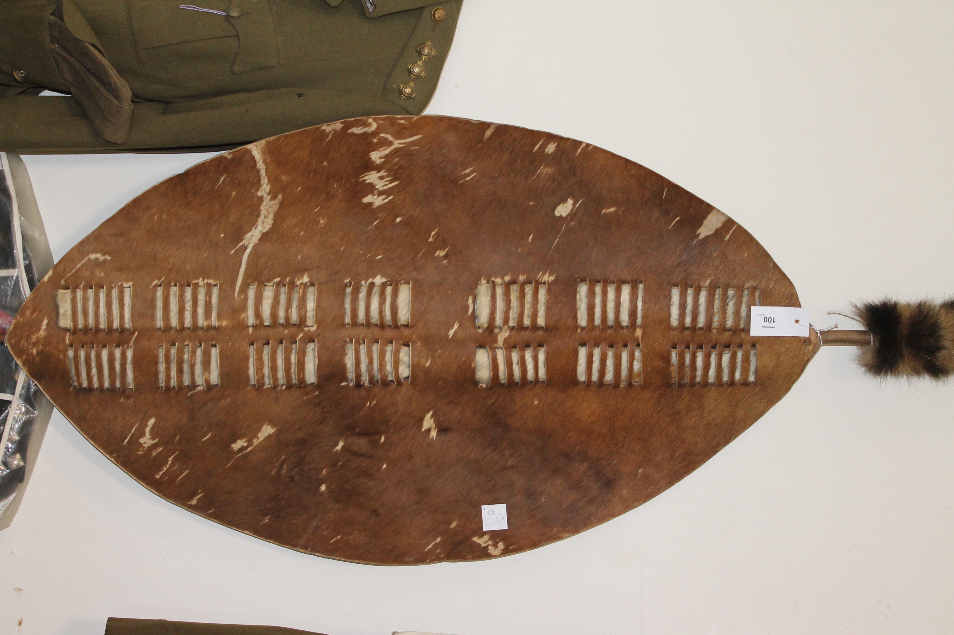 A ZULU WARRIORS SHIELD. Of classical design in a brown cowhide, with ...