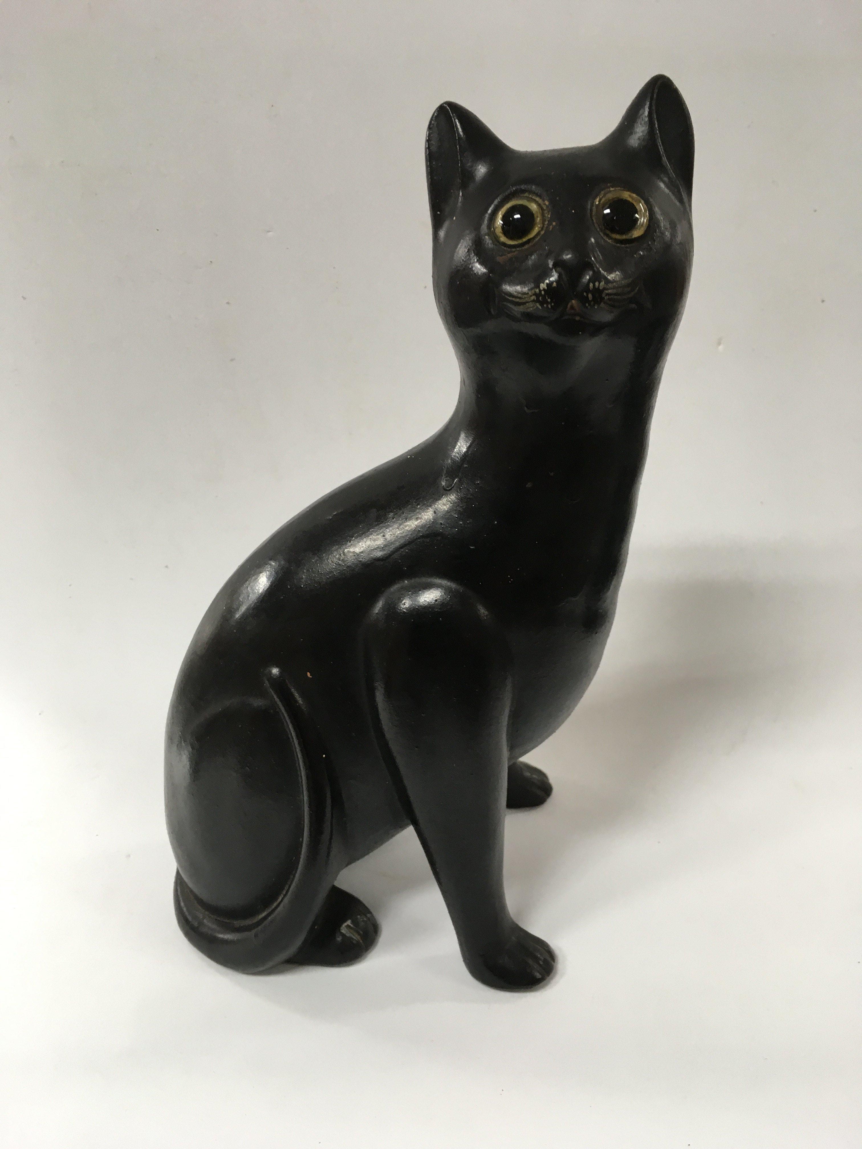 A Bretby pottery cat with glass eyes, approx 23.5cm.