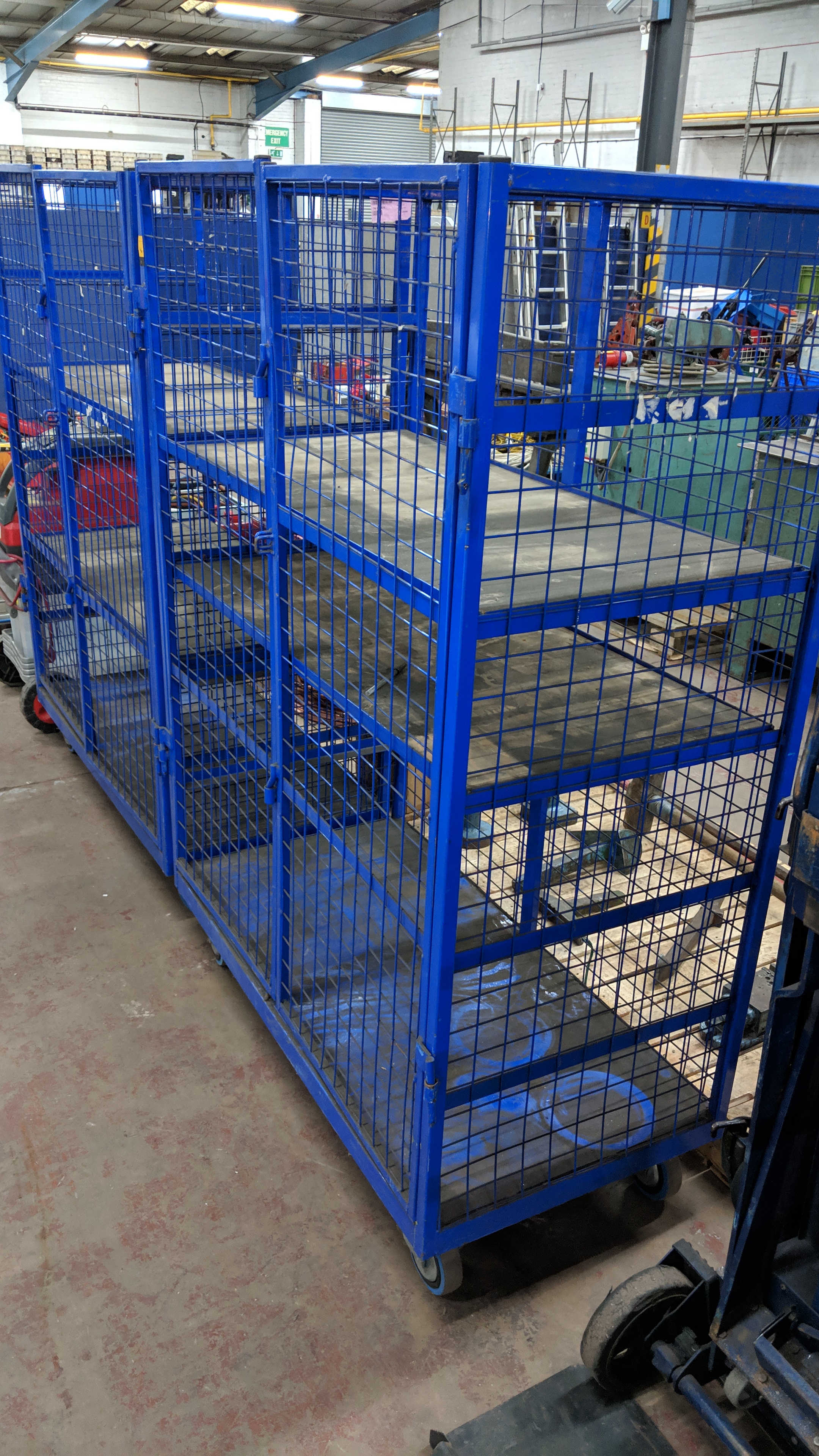 2 off blue lockable cage trolleys, each with 2 height adjustable ...