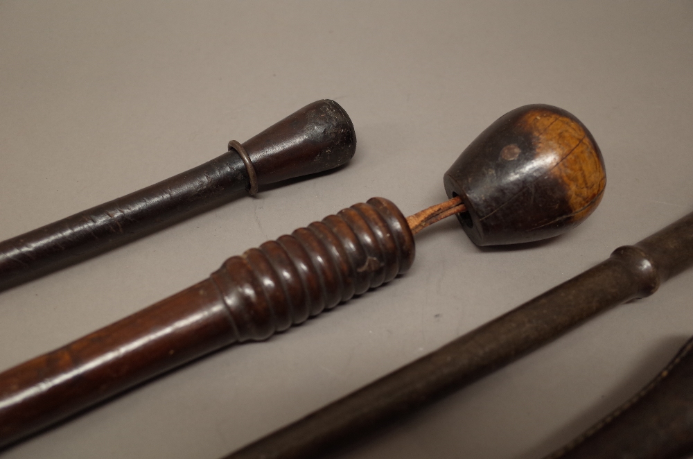 Four leather bound weighted coshes/whips and one further wood and ...
