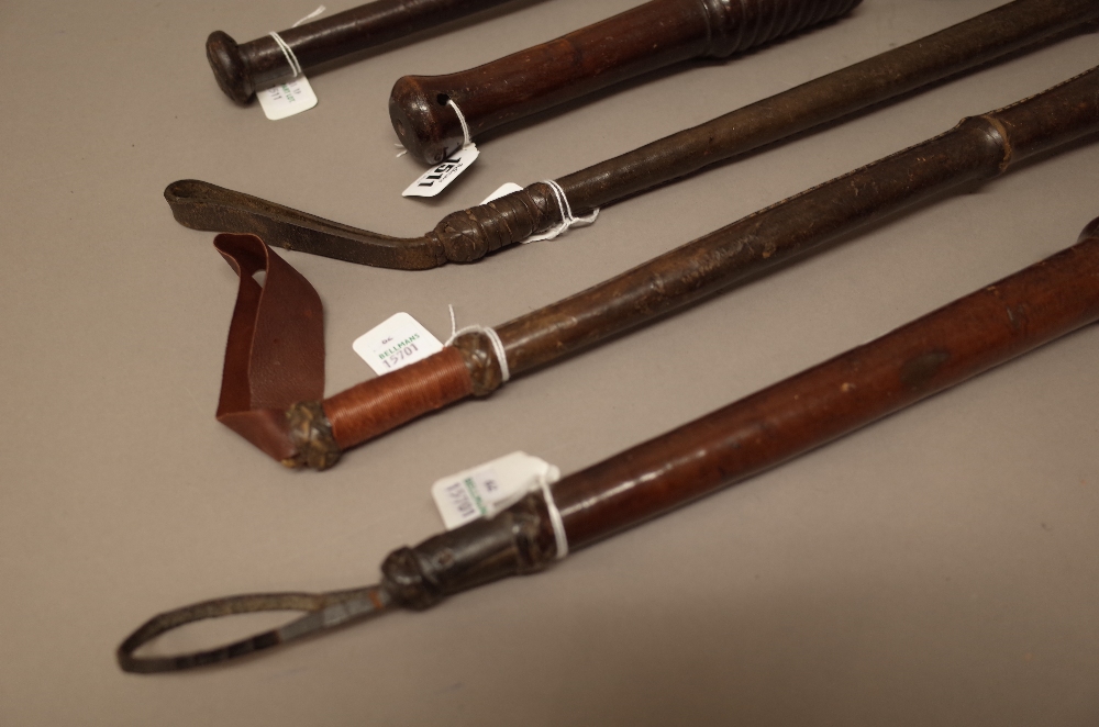 Four leather bound weighted coshes/whips and one further wood and ...