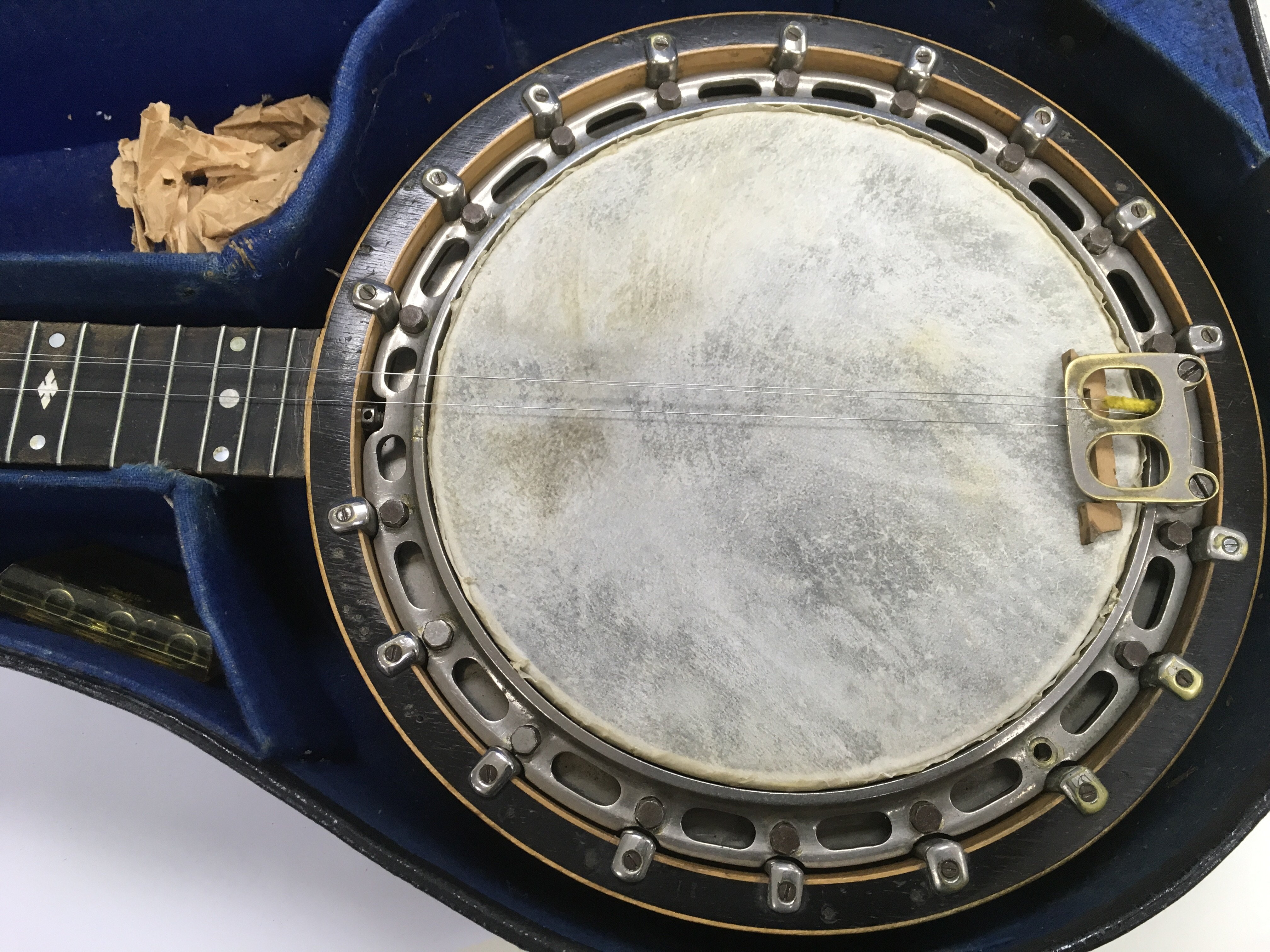 A cased banjo with mother of pearl inlays.
