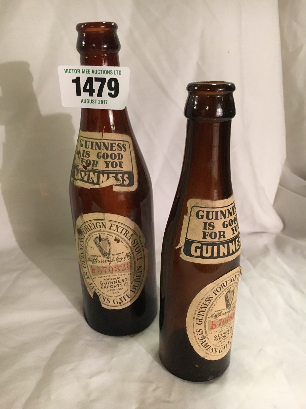 Two early machine made GUINNESS bottles with original labels.