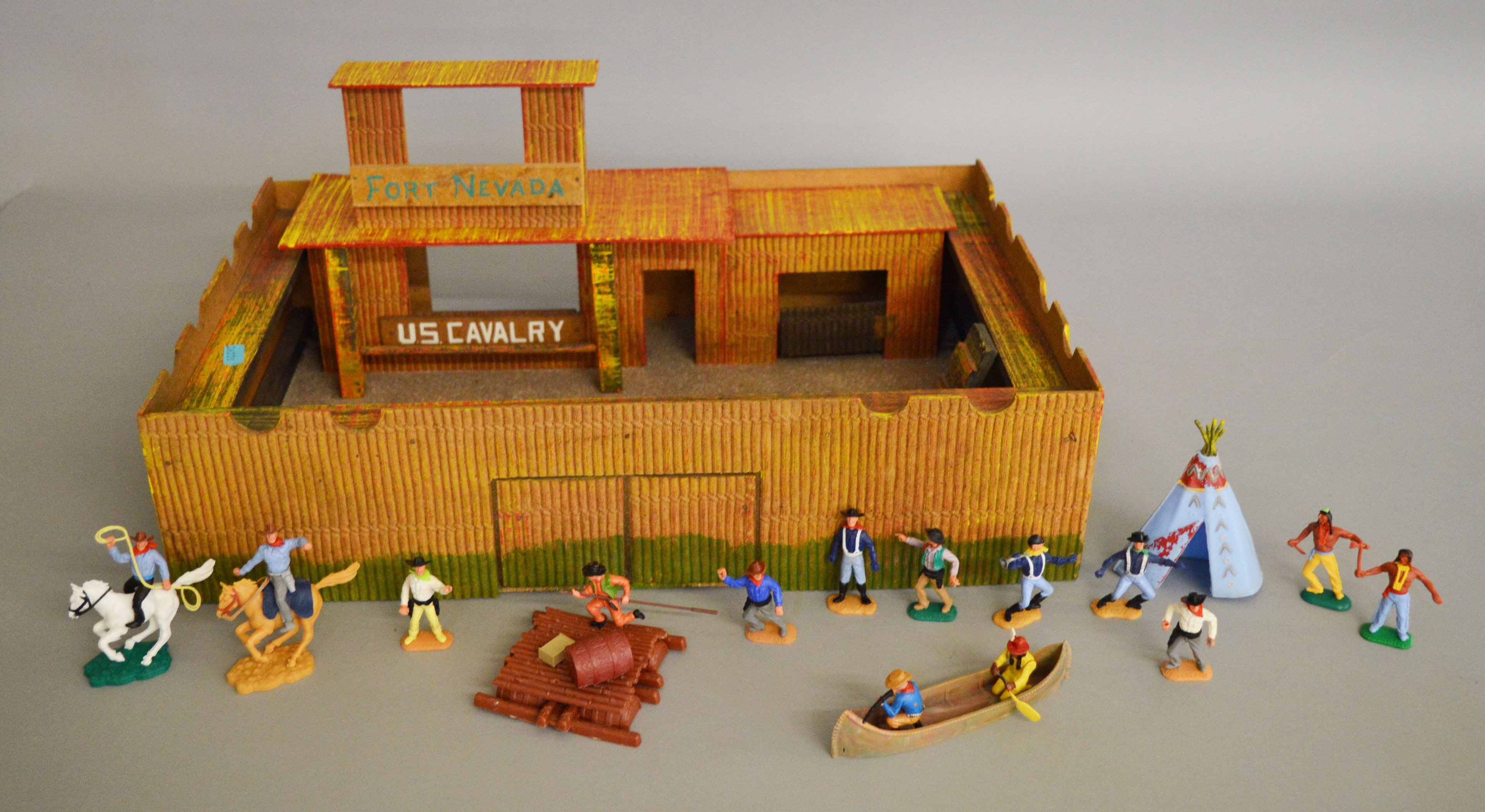 Timpo cowboys and accessories along with a wooden Wild West fort.