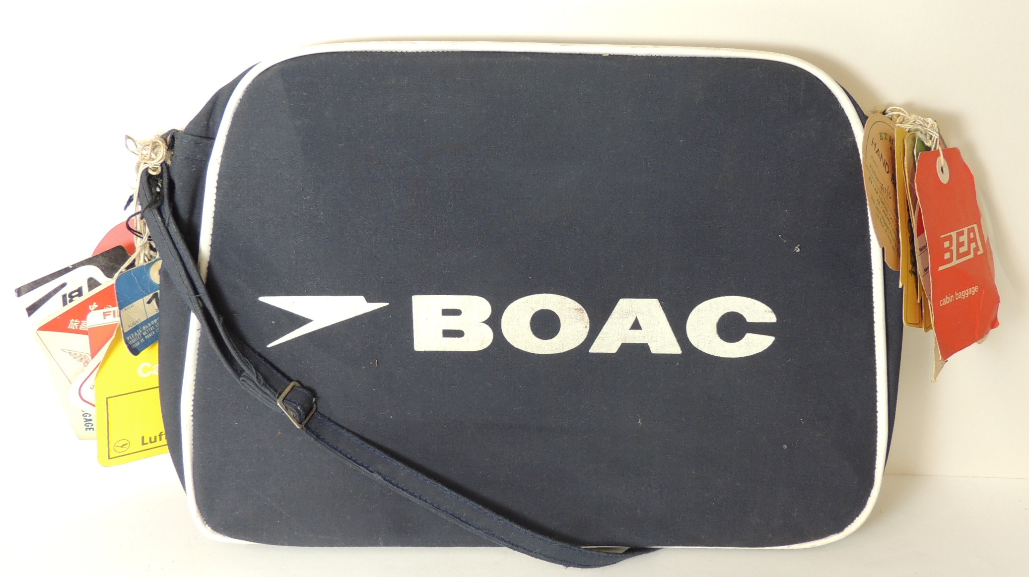 A BOAC cabin bag with many attached flight labels for BOAC First Class ...