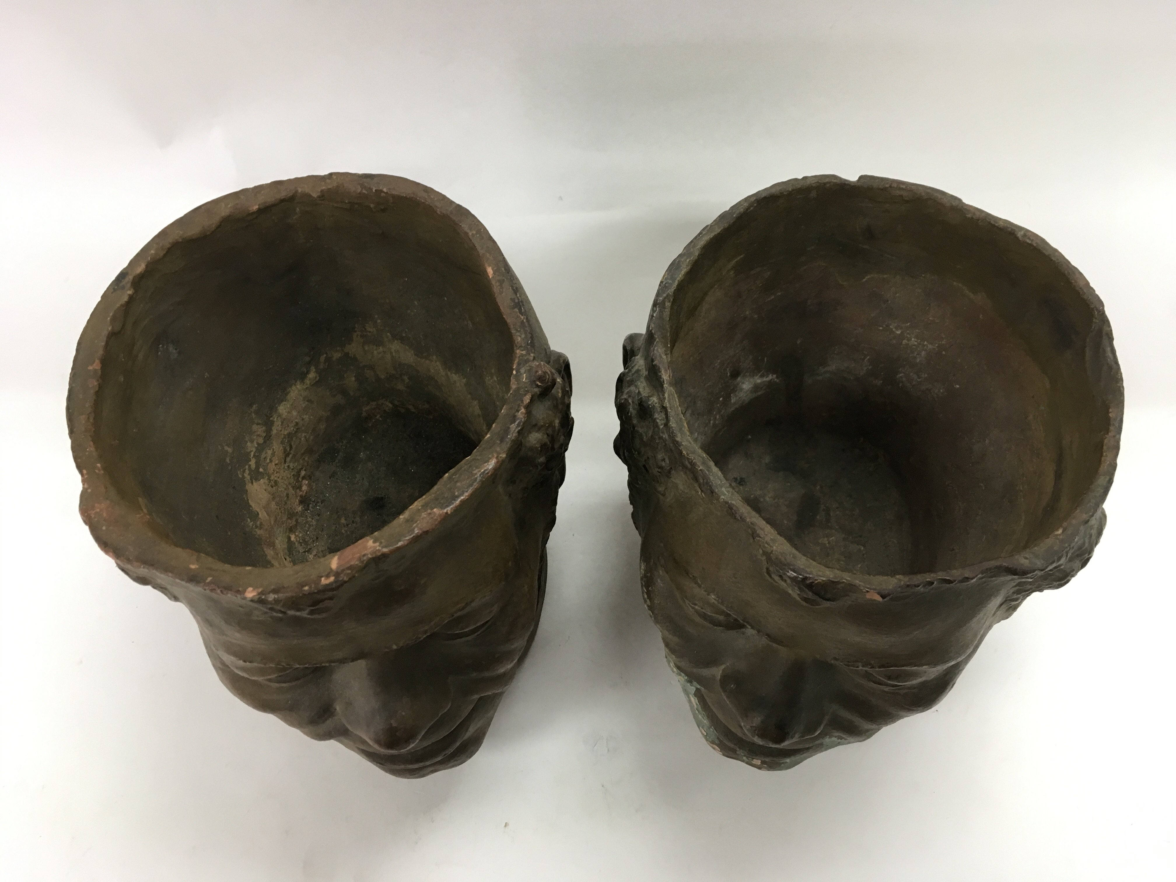 A pair of pottery vases in the form of human heads, approx height 17.5cm.