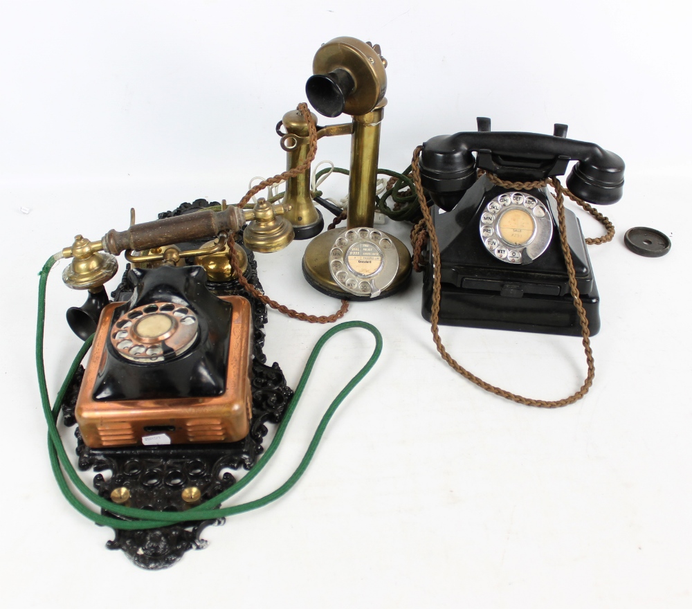 Three early 20th century telephones to include a brass candlestick ...
