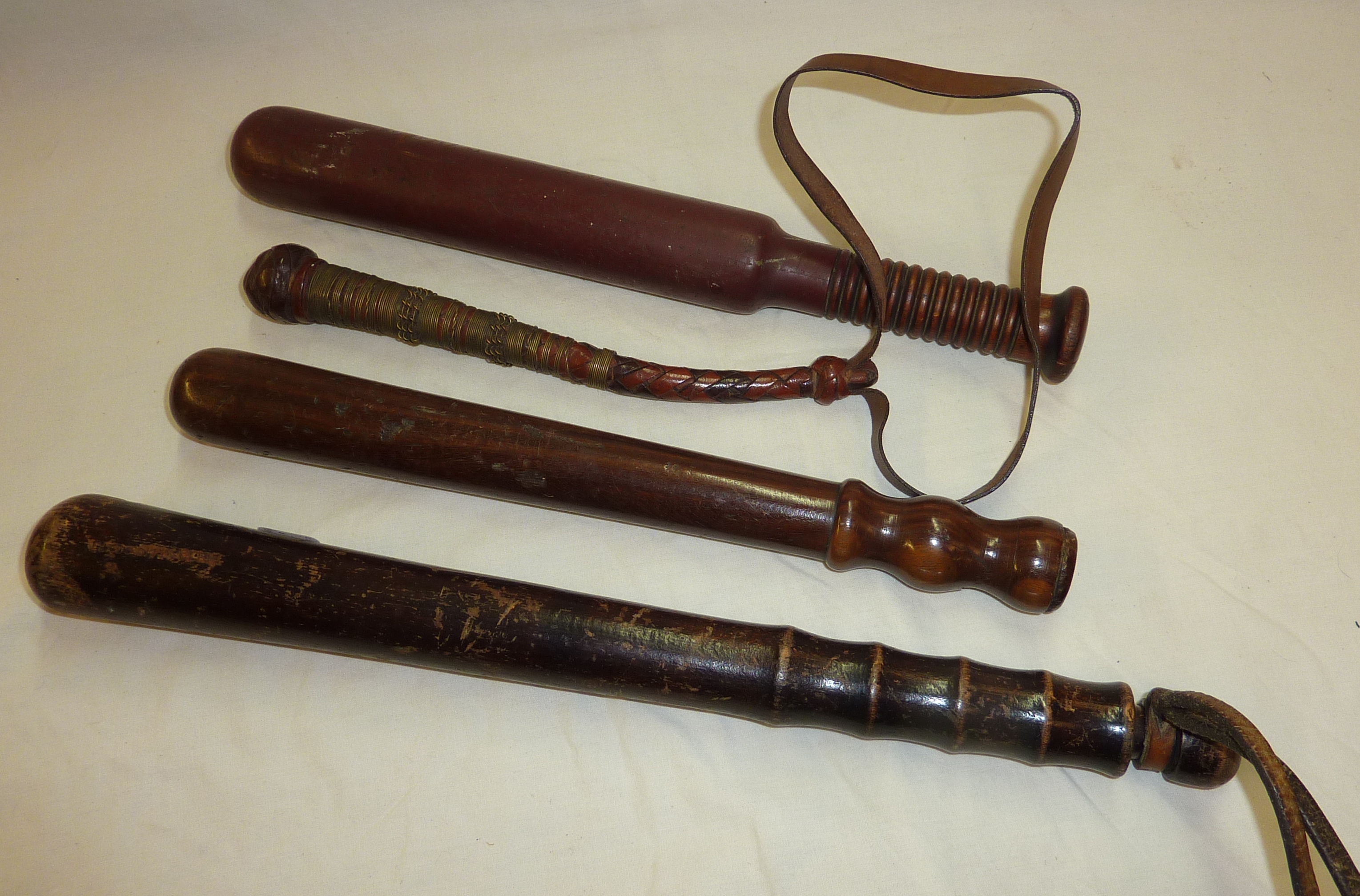 Three turned wood police truncheons and a braided leather cosh (4)