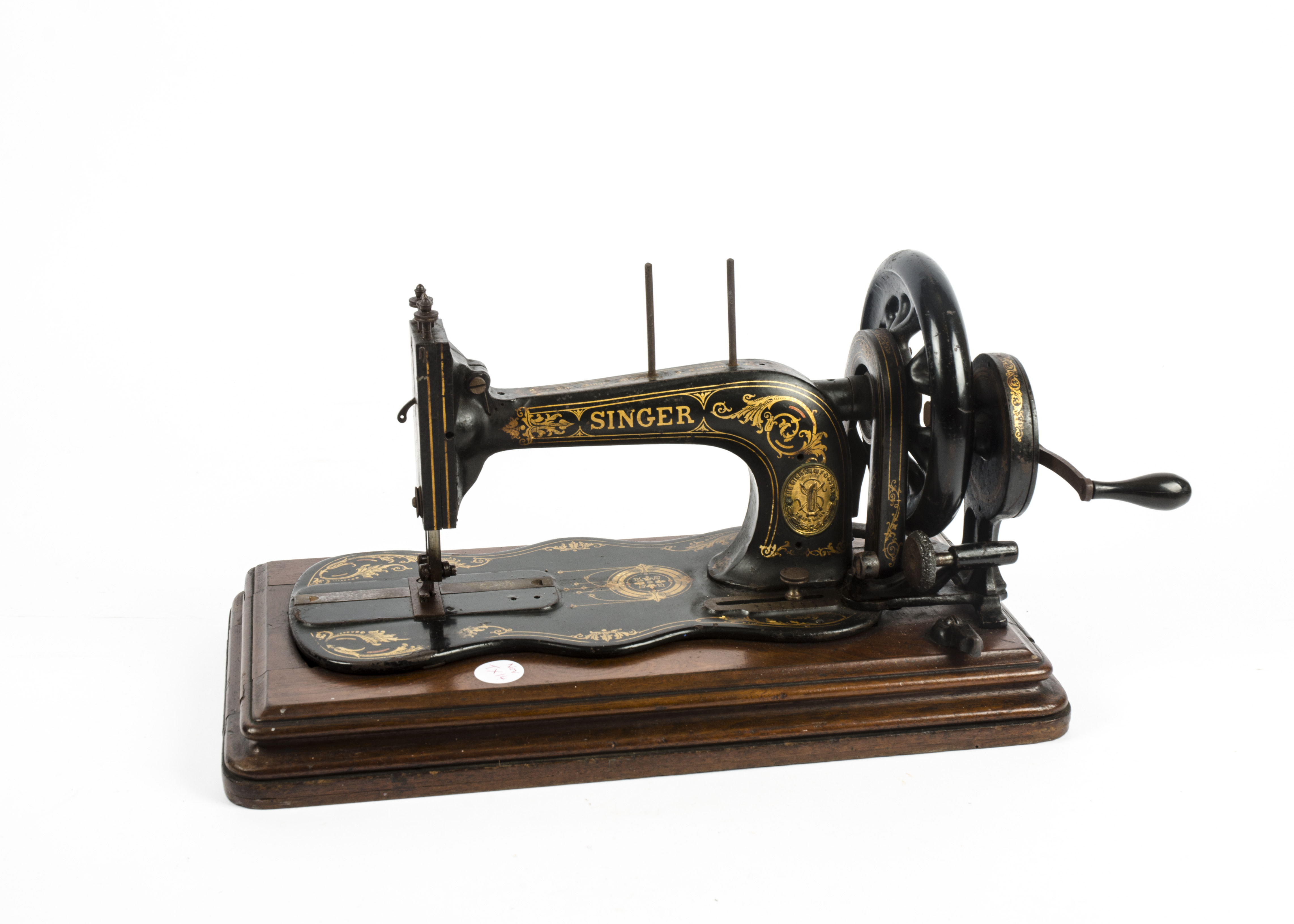 A Victorian Singer hand cranked sewing machine, attached to a hinged ...