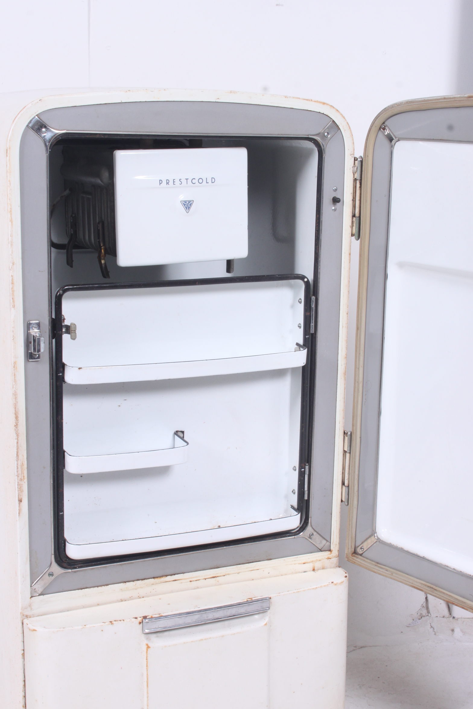 A vintage 1950's Prestcold fridge having the original enamel painted ...